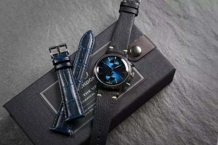 relógio de pulso desfeito com cinto preto e azul