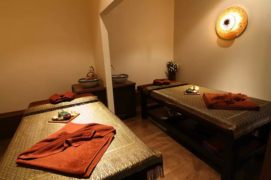sala de masaxes de estilo tailandés con 2 camas individuais
