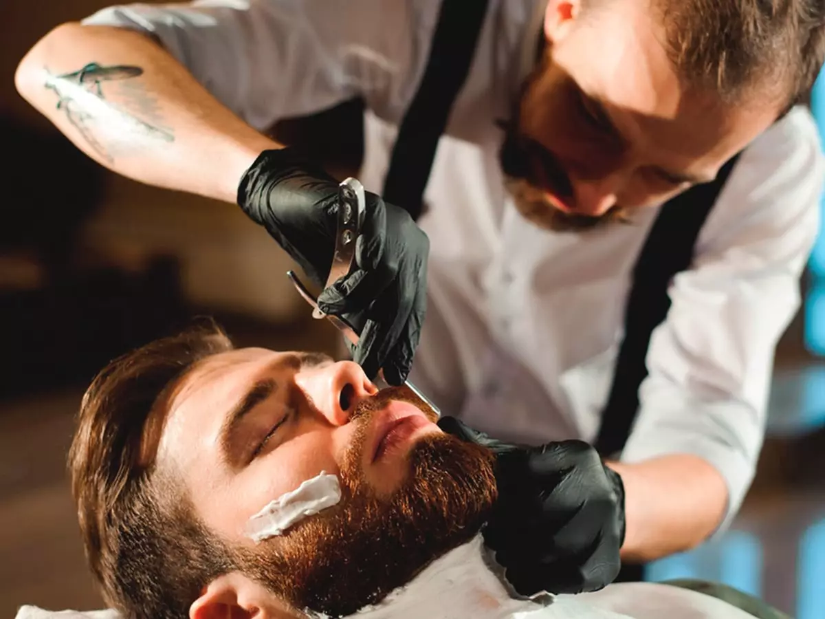 آرایشگر شیک ریش مردانه را مرتب می کند