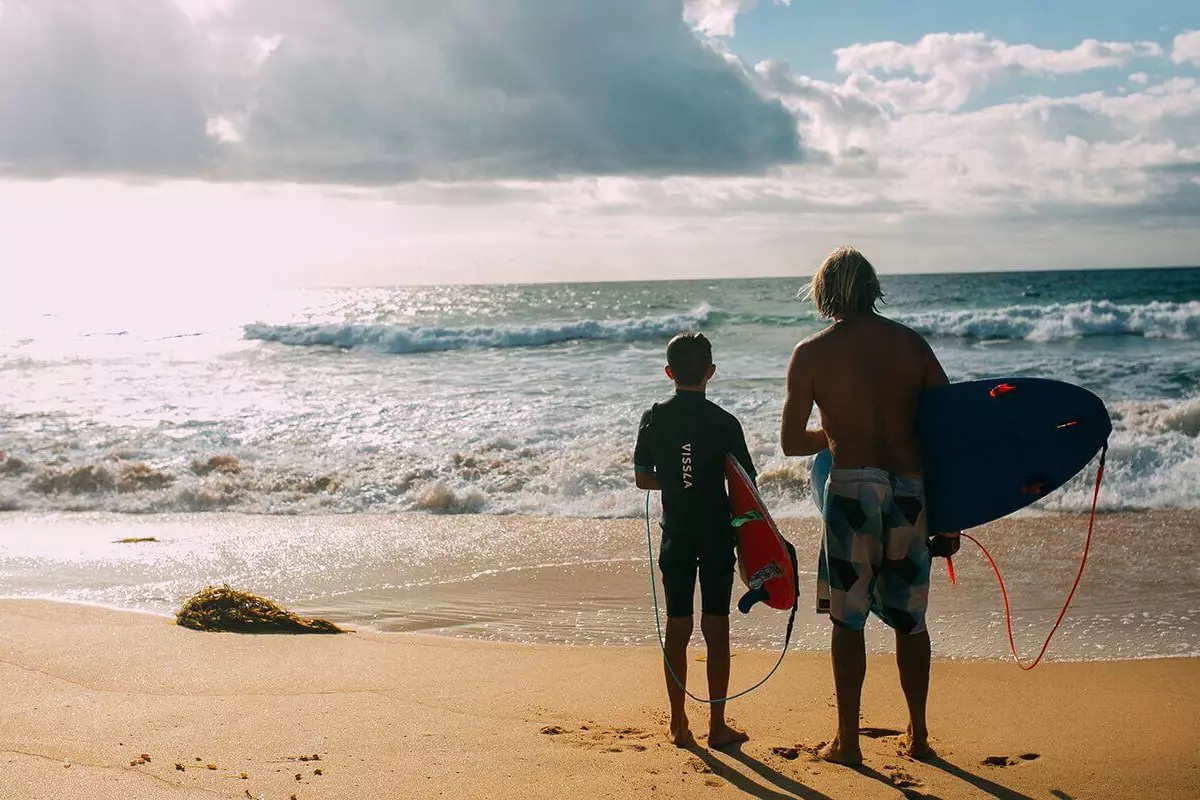 dous surfistas de pé na praia de Shelly