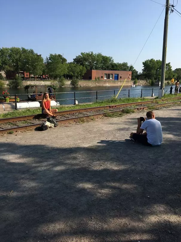 mujeres tomando fotos para sentarse en la vía férrea