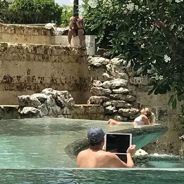 hombres tomando fotos sentados en la piedra