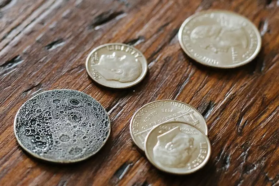 Сребрни новчић пуног месеца стављен у сто