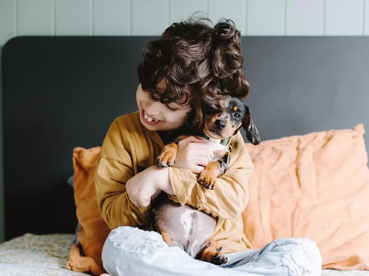 anak yang bahagia dengan anak anjing