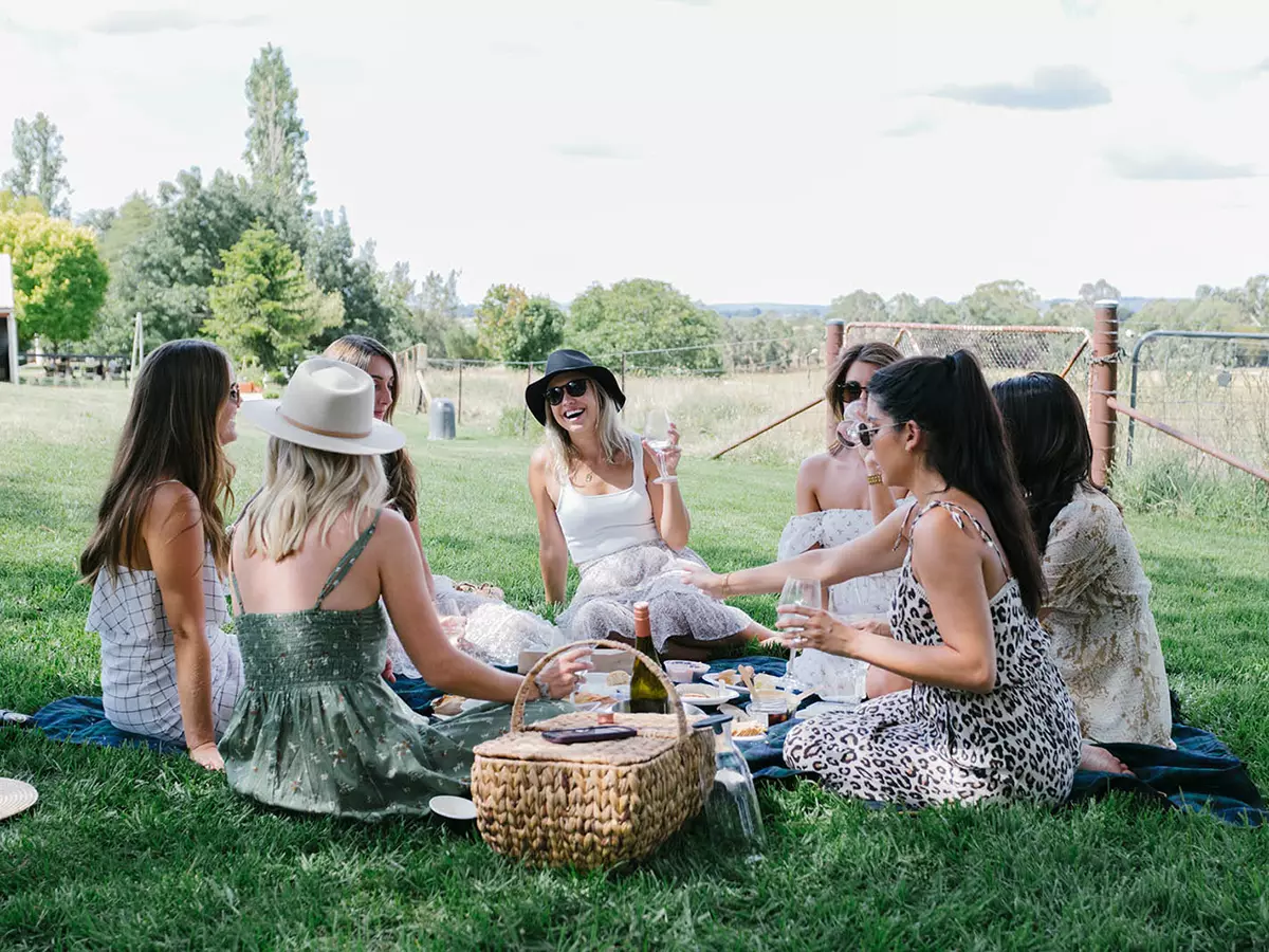 grupp unga kvinnor som har picknick på rowlee viner