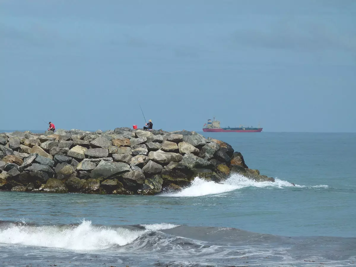 cottesloe rock groyne üzərində balıqçı