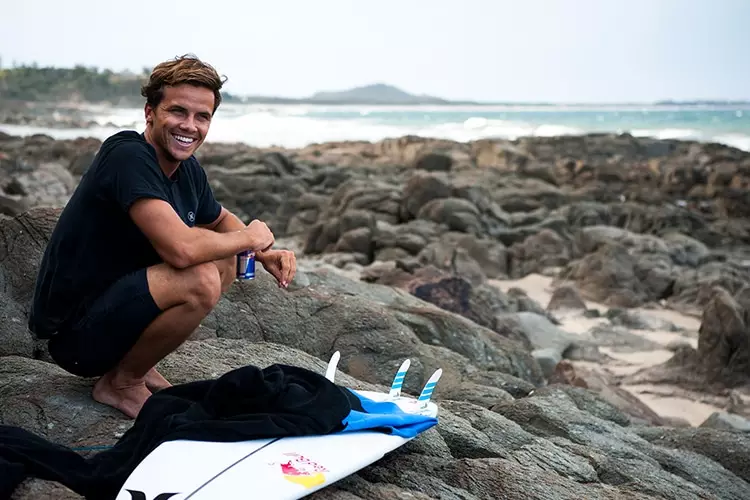 Surfer Julian Wilson sitzt auf dem Stein